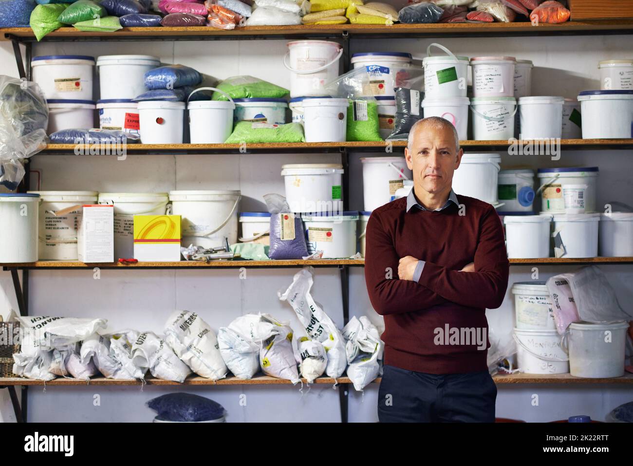 Hes a proud store owner. a store owner standing in front of his ...