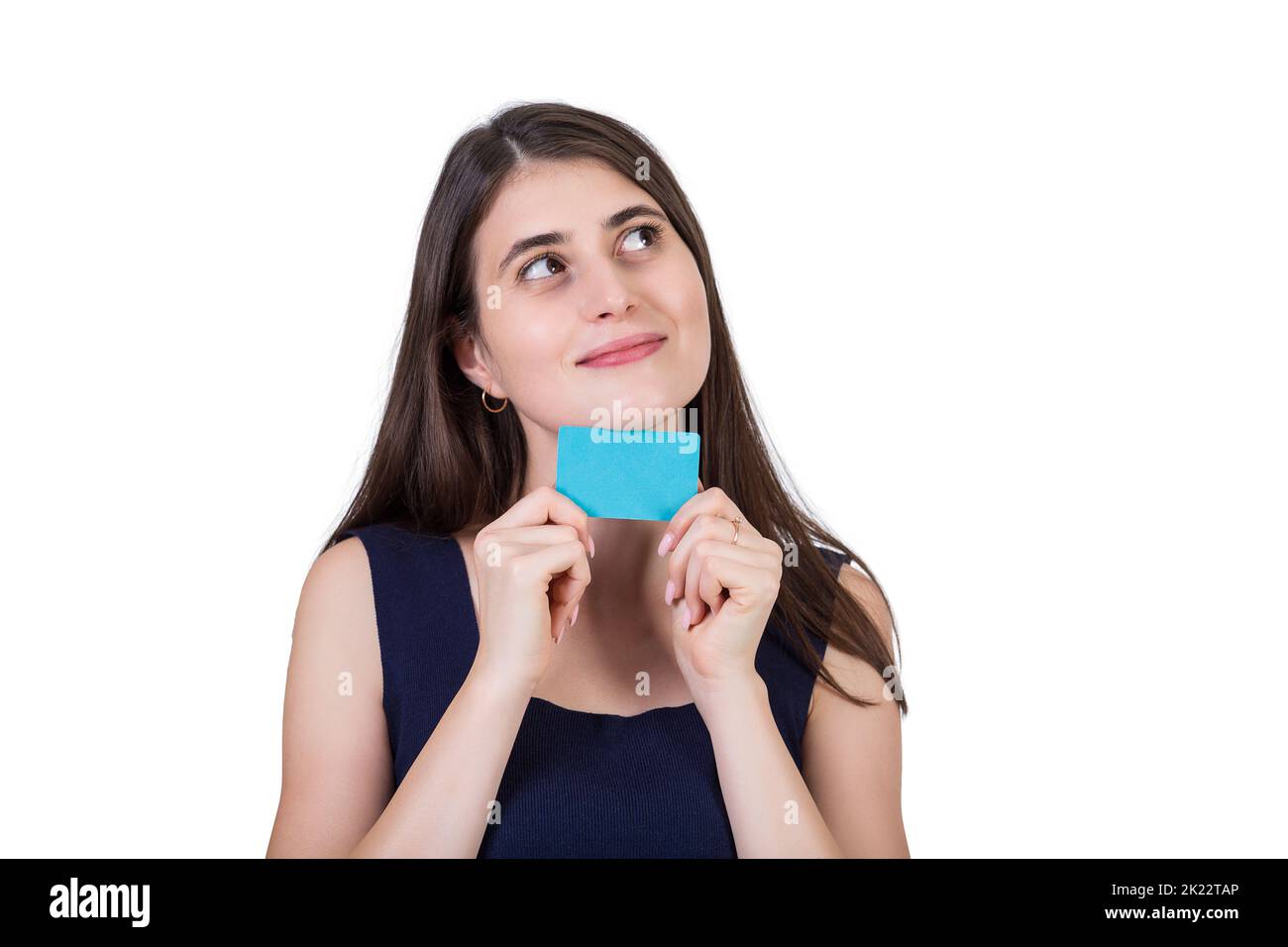 Thoughtful young woman looks dreamy aside while holding a blank gift ...