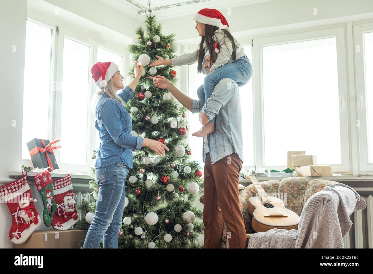 family near the Christmas tree in their living room Stock Photo - Alamy