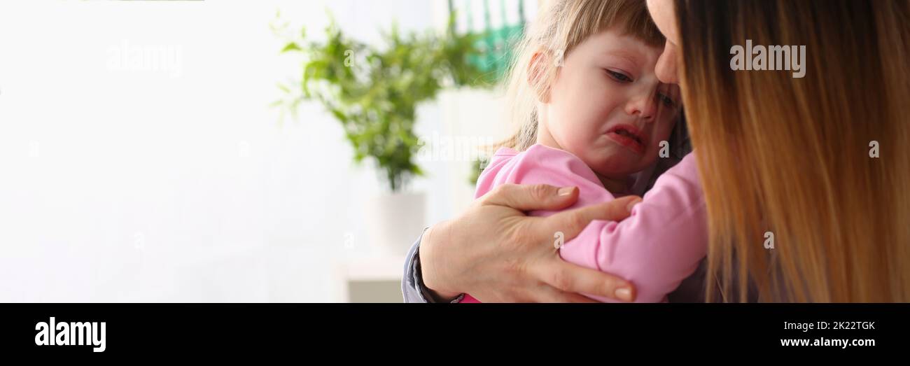 Mother consoles crying baby girl home closeup Stock Photo - Alamy