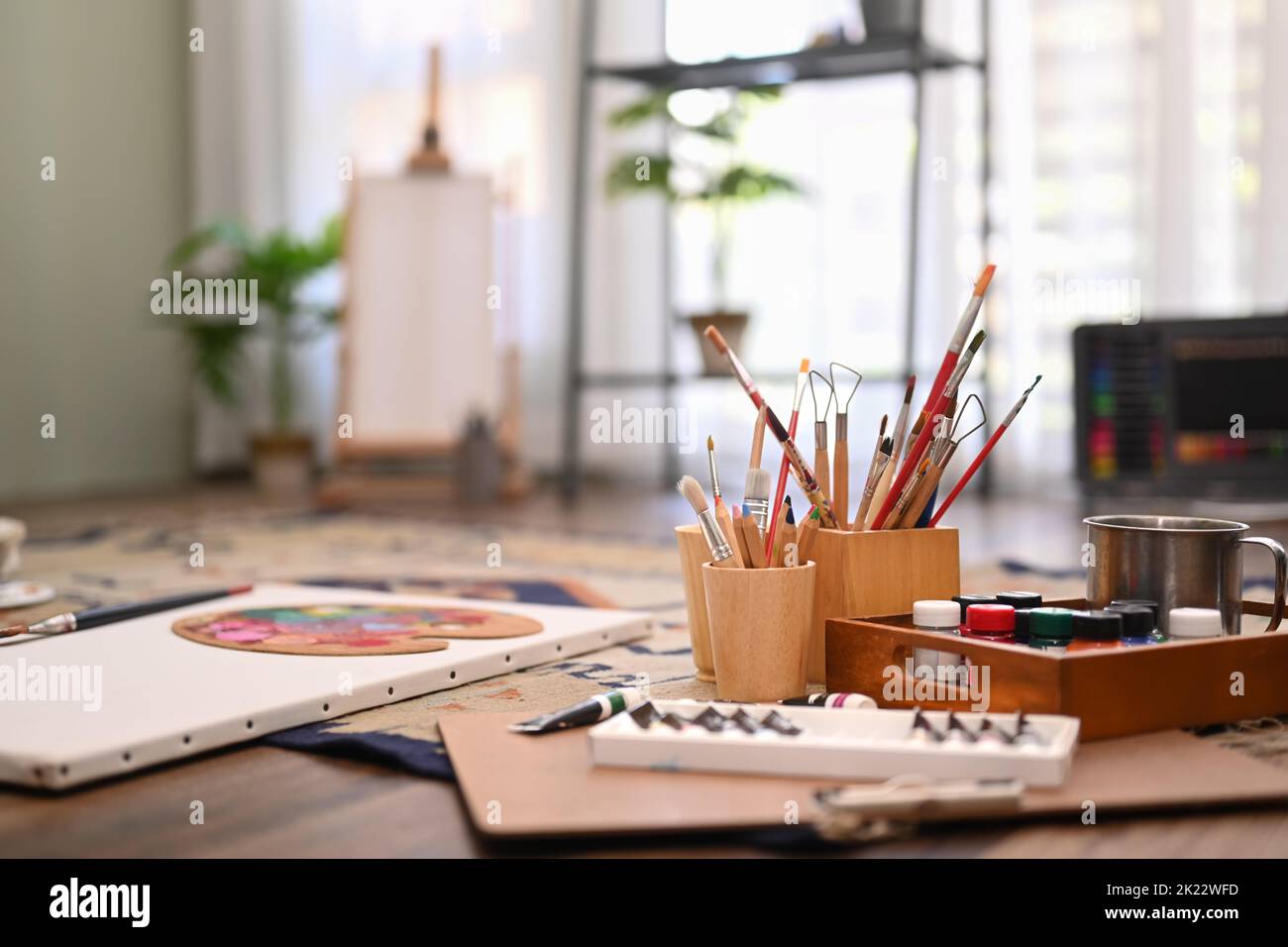 Artist studio interior with canvas, paint brushes, tubes of paint on ...
