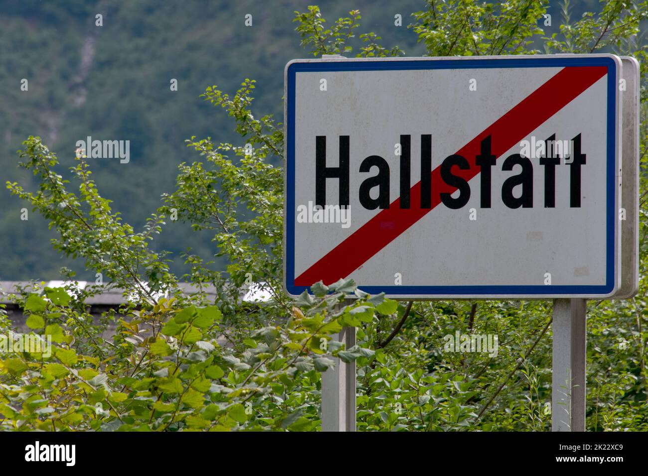 Closeup sign with bushes and mountains background end crossed out wold ...