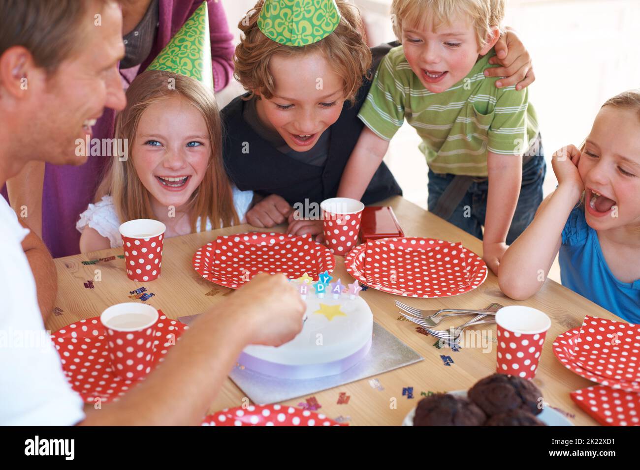 Its cake time. Cute young family having a childrens birthday party ...