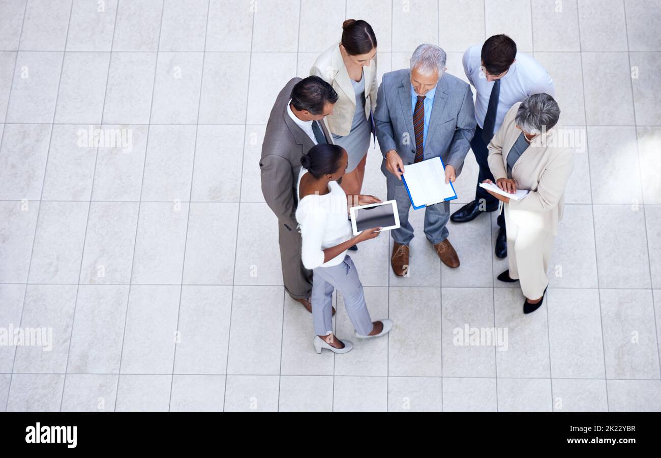 Getting down to business. a diverse business team discussing paperwork ...