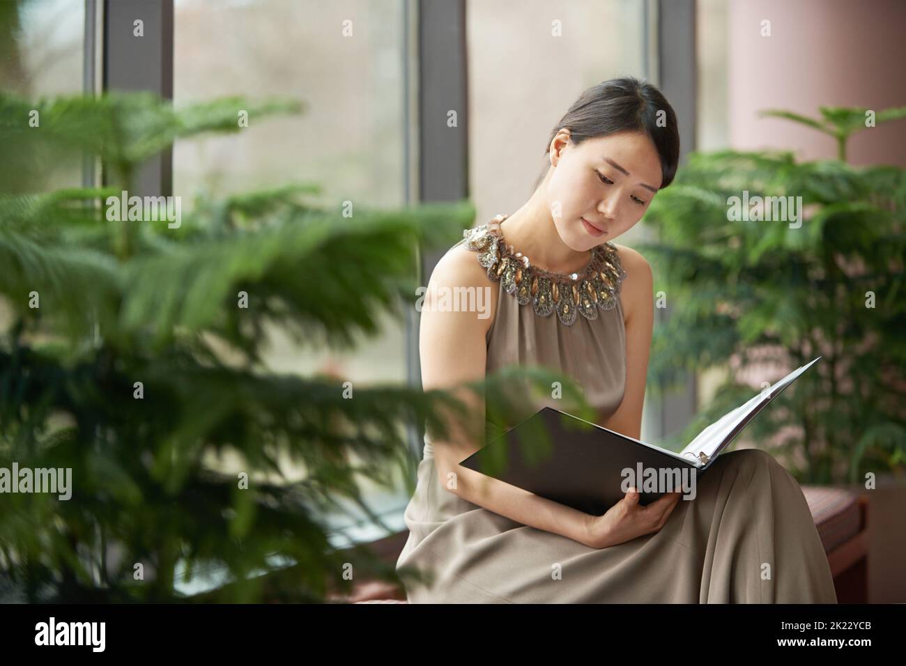 Picking the perfect musical piece. an elegantly dressed young woman ...