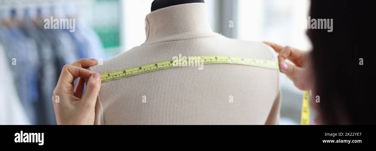 Female tailor takes measurements on mannequin closeup Stock Photo - Alamy