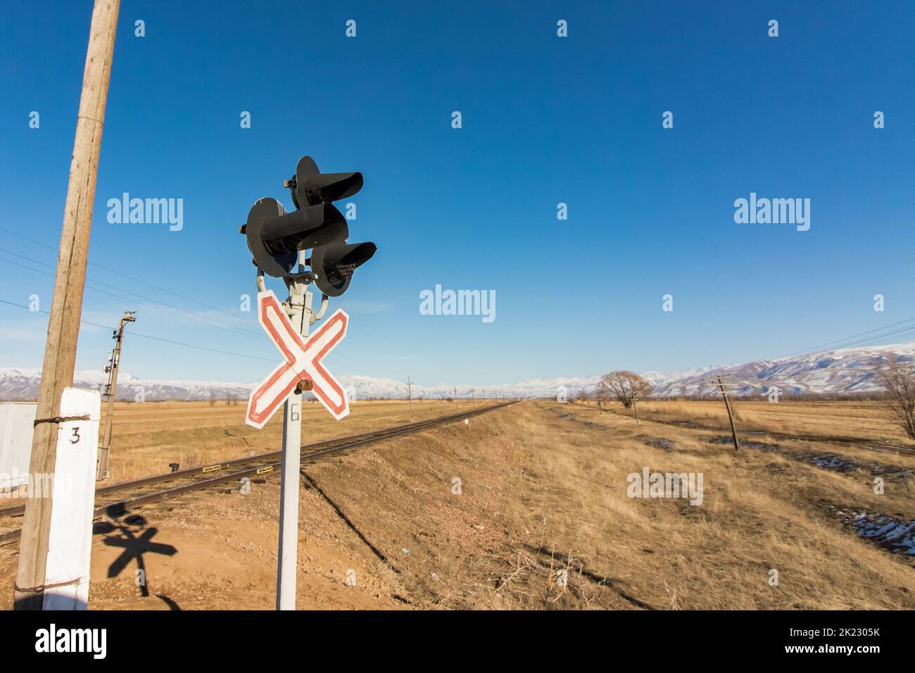 Rail crossing in the countryside of Kyrgyzstan with mountains on the ...
