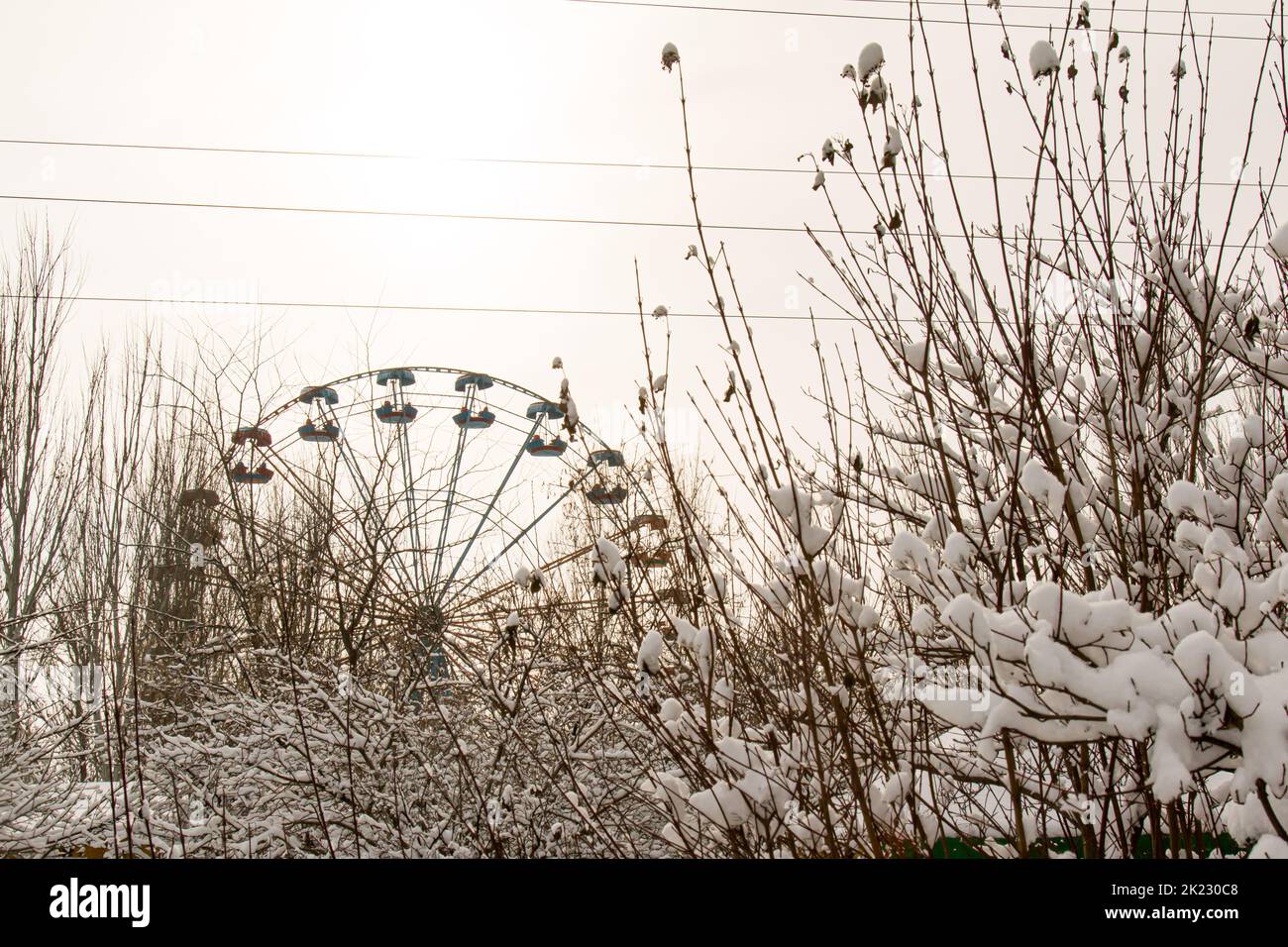 Sunset view of the Bishkek ferris wheel in a park covered with snow ...