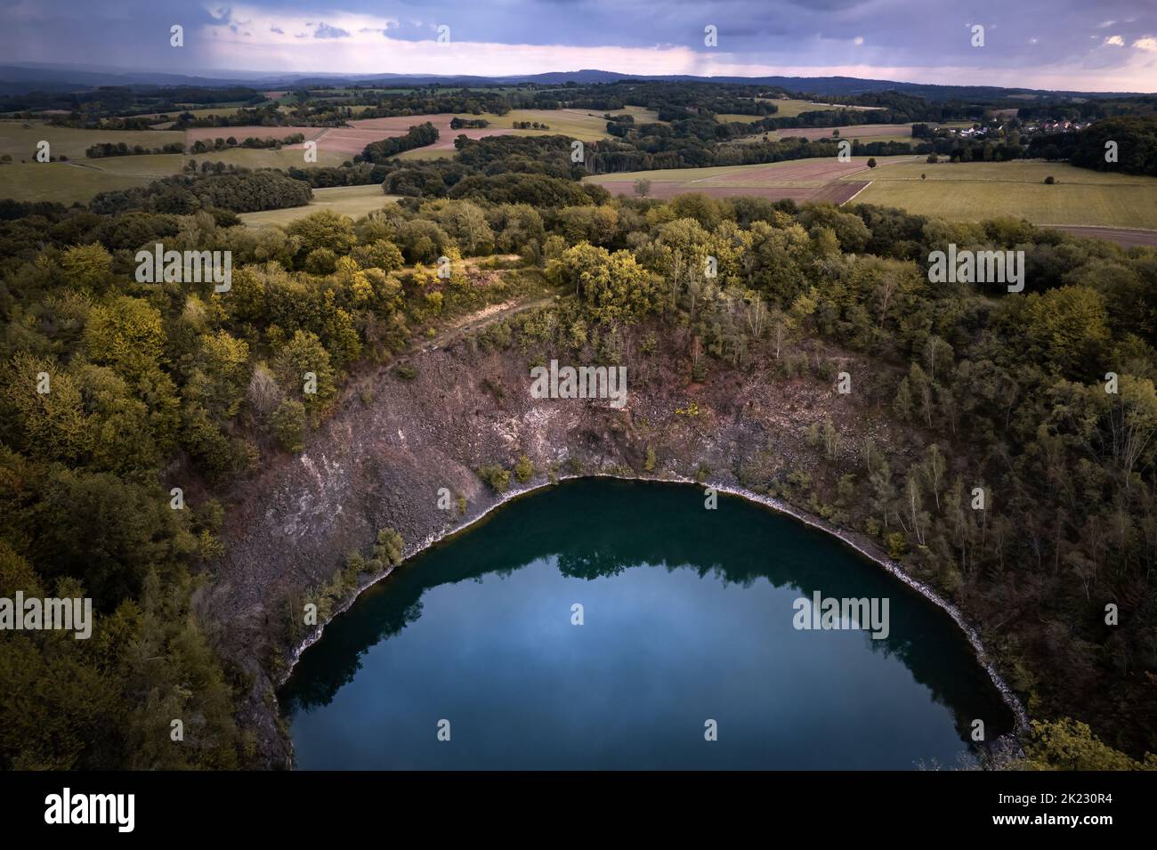 Small blue crater lake of a dormant volcano surrounded by forest in ...