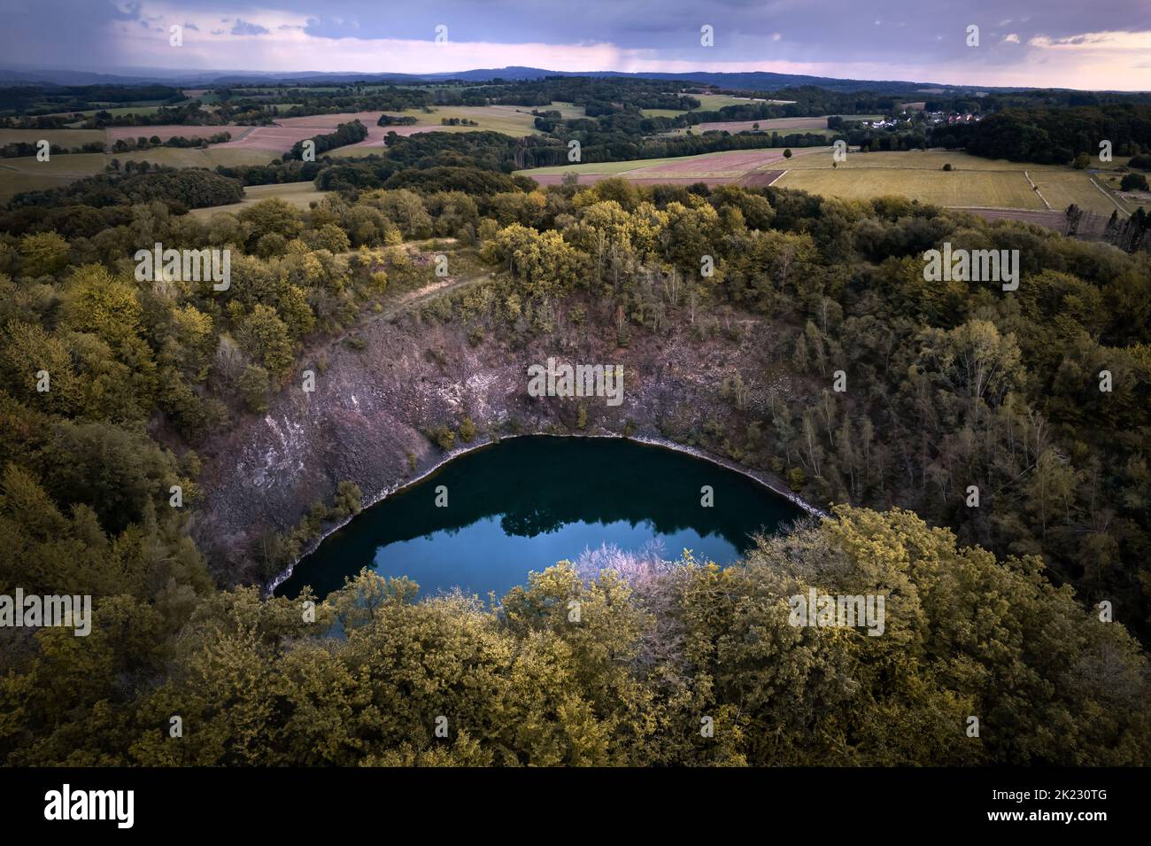 Small blue crater lake of a dormant volcano surrounded by forest in ...