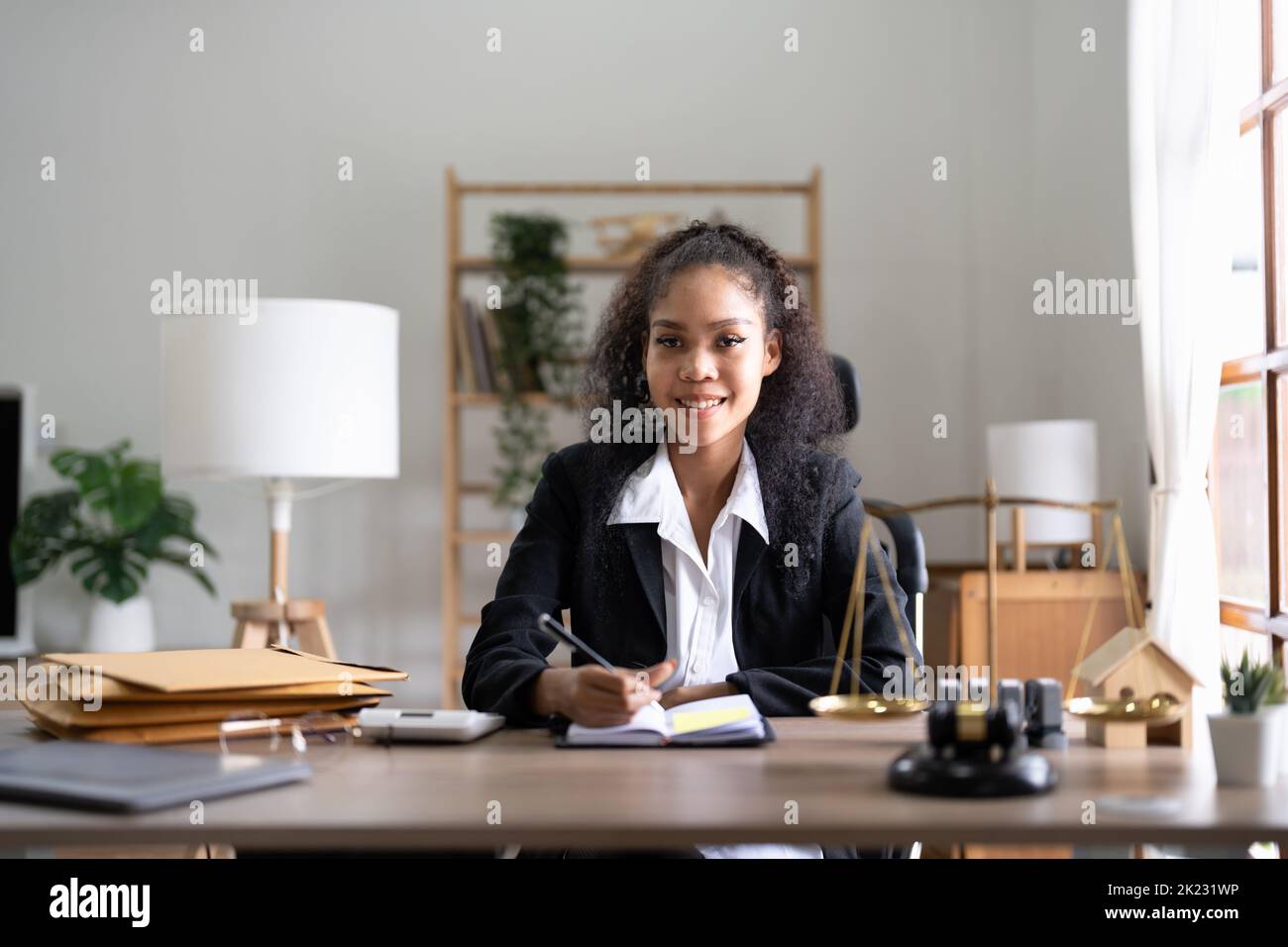 Portrait smiling female lawyer sitting at workplace in office Stock ...