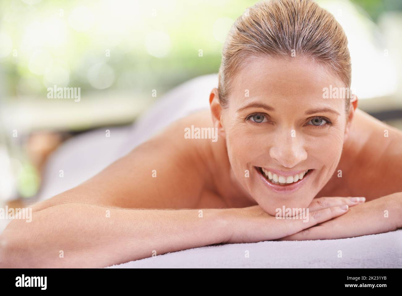 Total bliss. a woman in a day spa relaxing on a massage table Stock ...