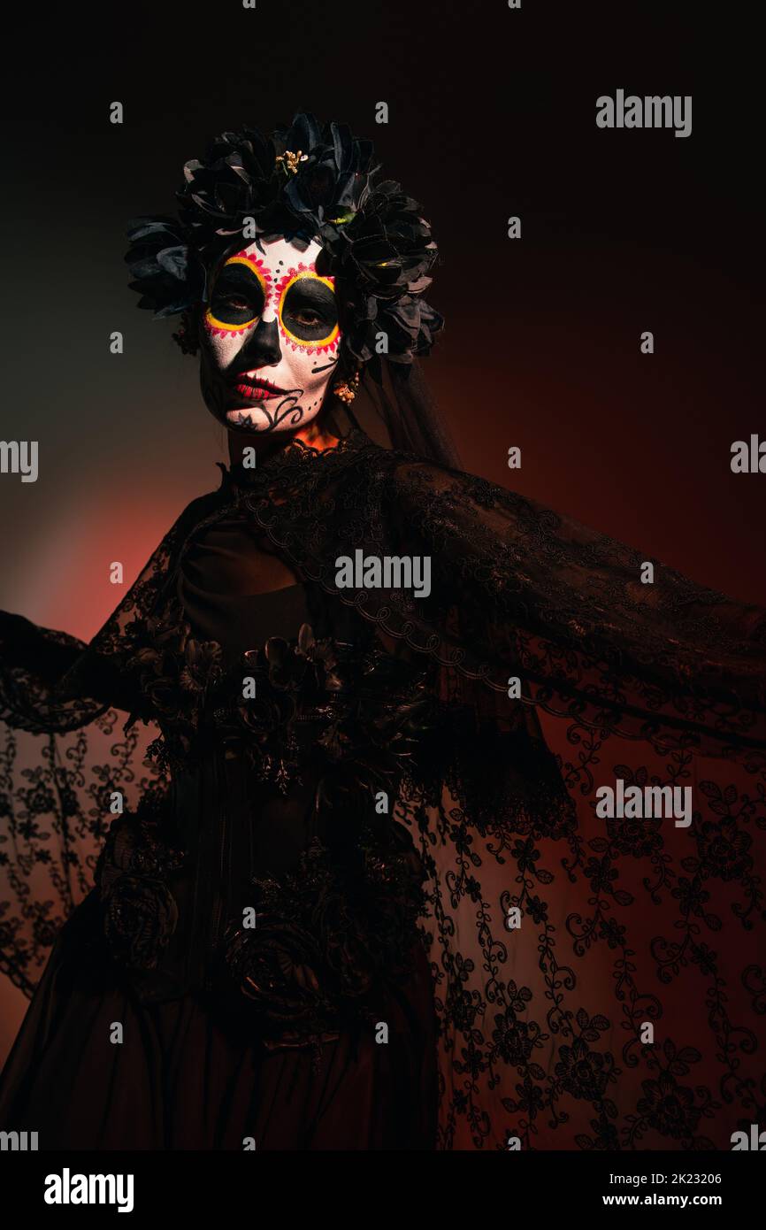 Woman in traditional mexican santa muerte costume looking at camera on ...