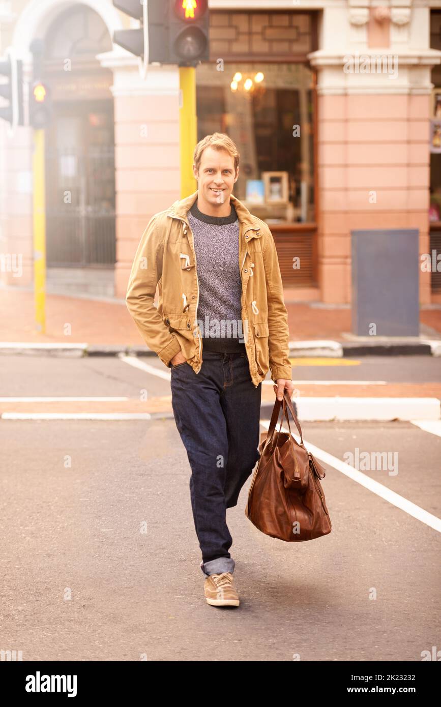 Travelling light. Full length shot of a handsome man walking across an ...