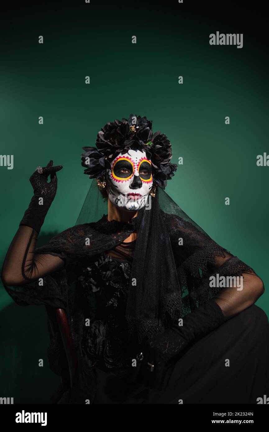 Woman in scary santa muerte costume posing on green background,stock ...