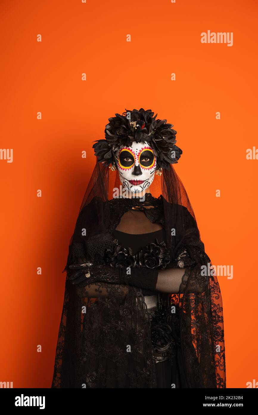 woman in black witch costume and traditional mexican day of dead makeup ...