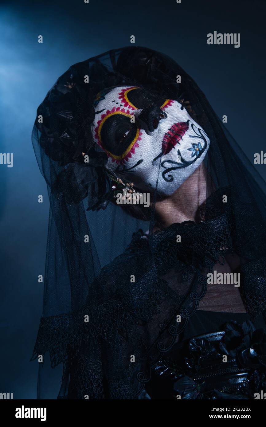 woman in spooky halloween makeup and black veil posing on dark ...