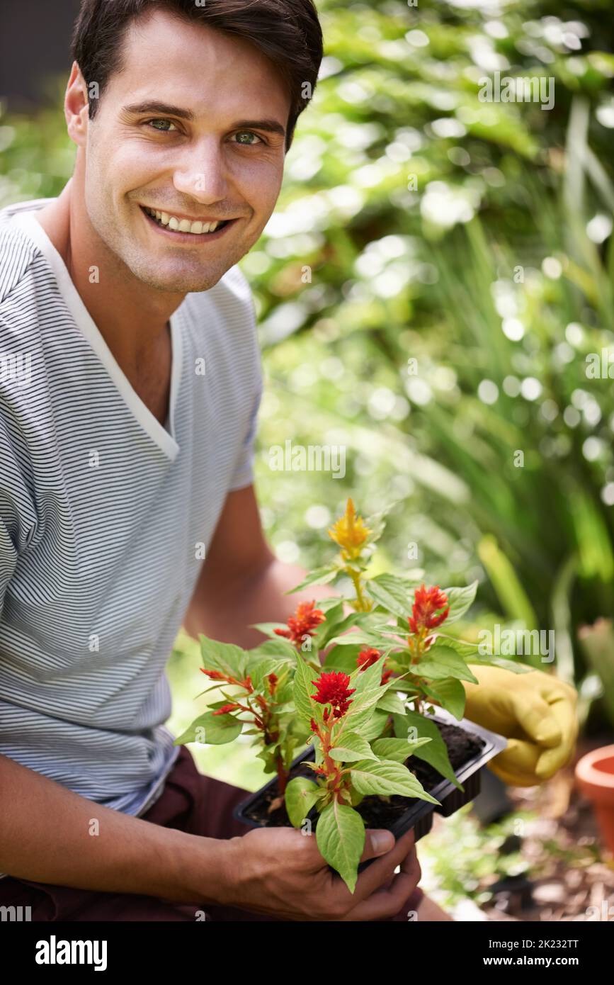 Gardening is great fun. Portrait of a handsome young man gardening ...