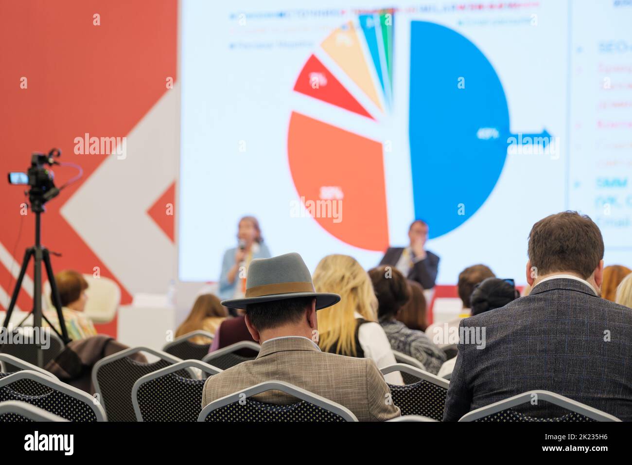 Group of people watching presentation on large screen and listening to ...