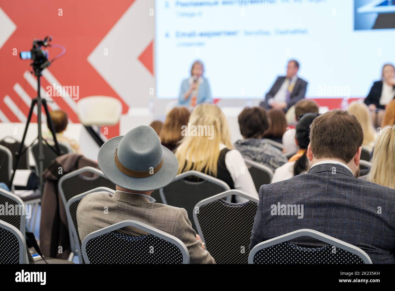 Group of people watching presentation on large screen and listening to ...