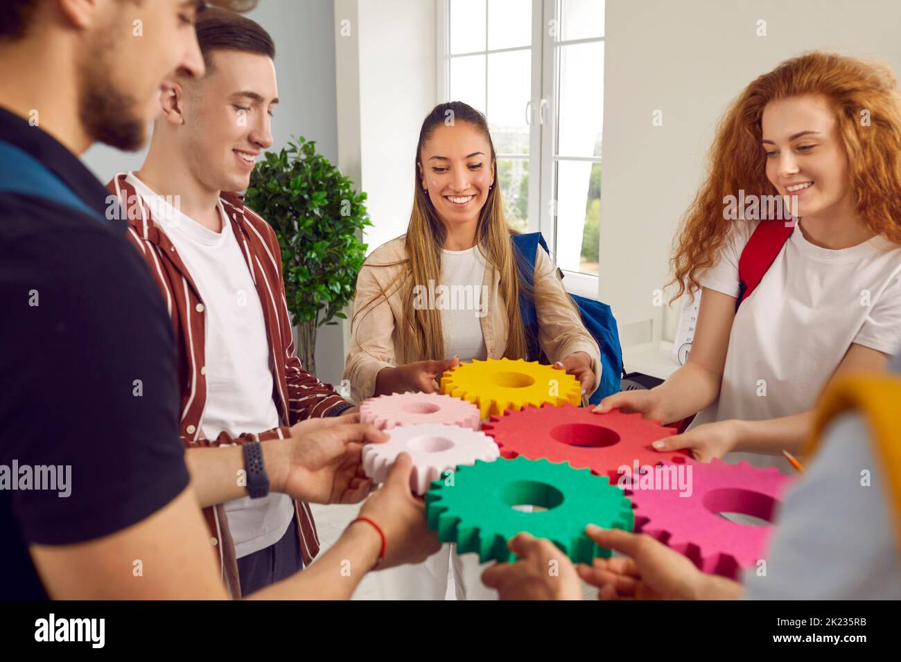 Team of happy smiling young university students working on creative ...