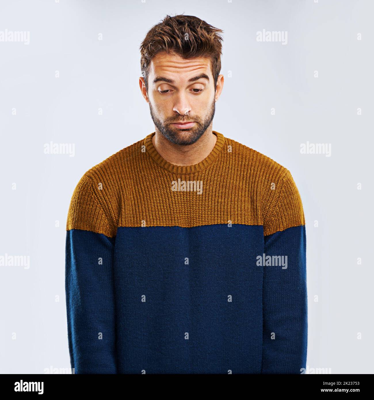 Sigh,I wish it was different...Studio shot of a young man looking ...