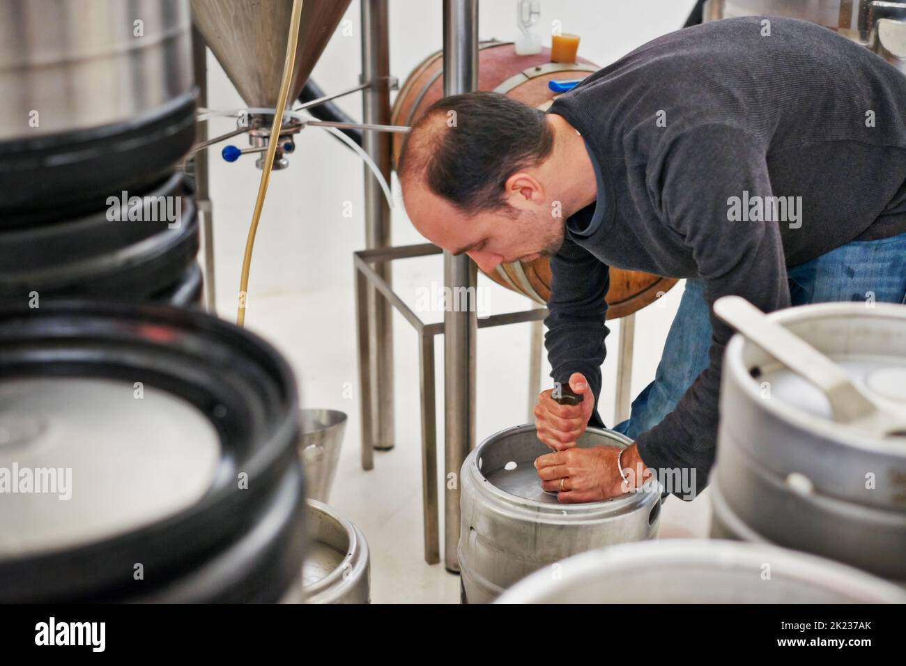 Sealed and ready to go. a man working in a microbrewery Stock Photo - Alamy