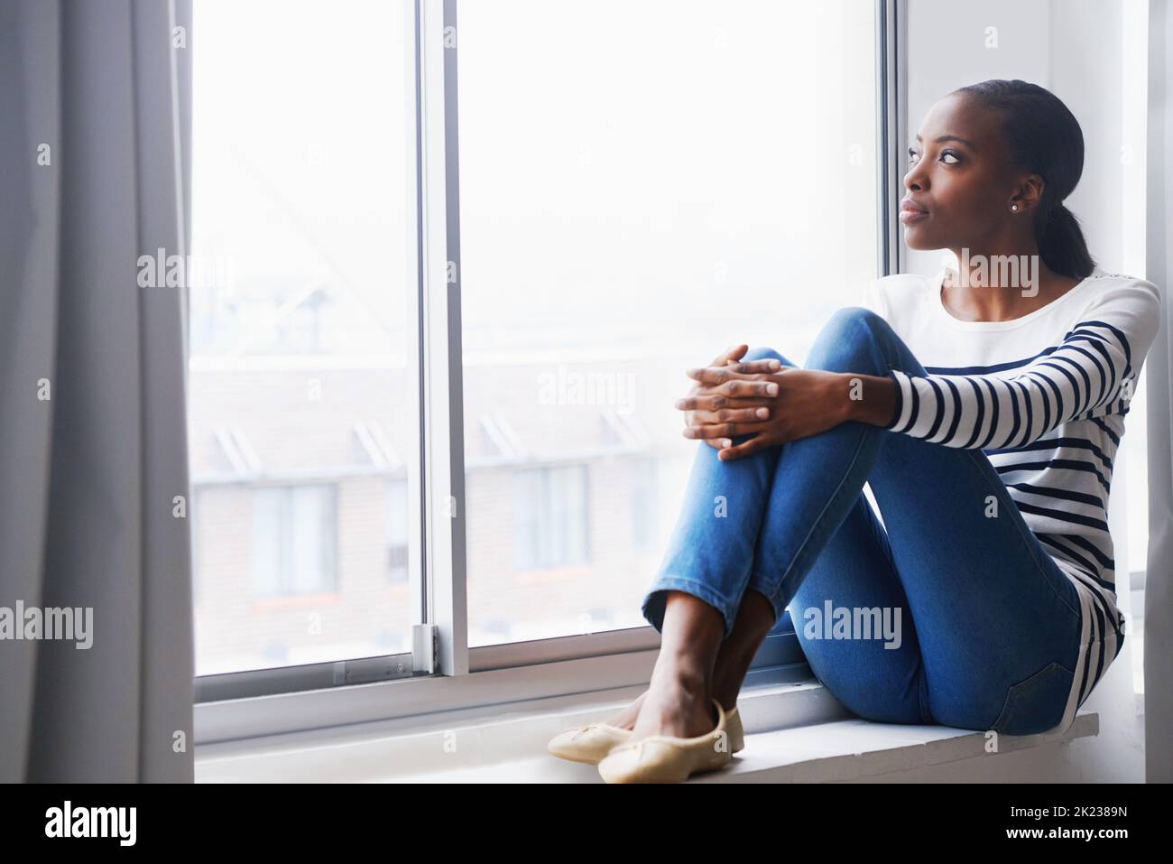 Waiting for inspiration to strike. A beautiful young woman lost in thought while sitting on a ...