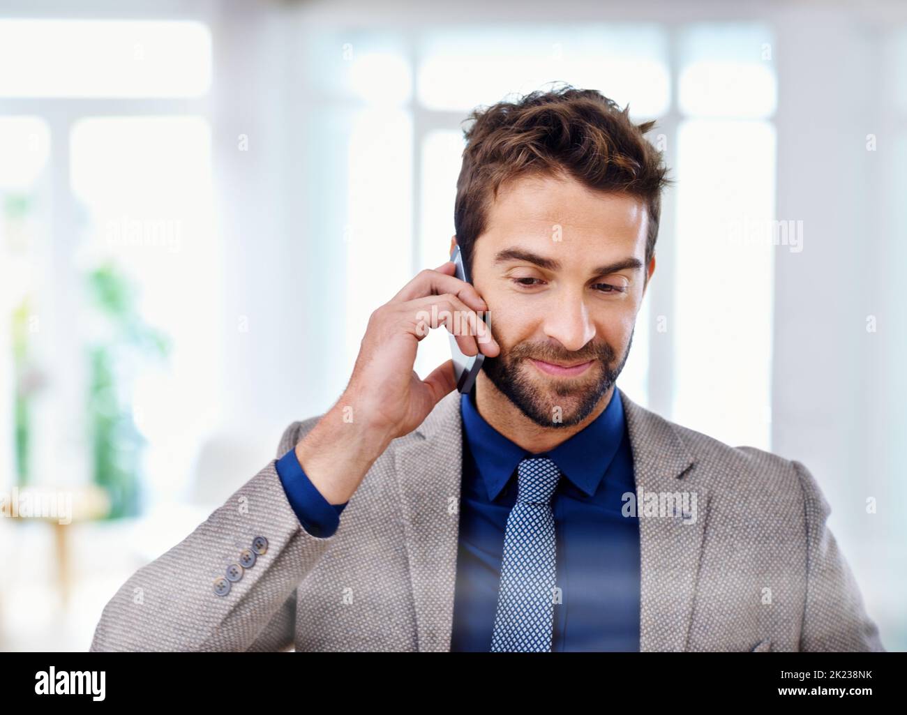 Listening intently. A man in a contemporary suit talking on his ...