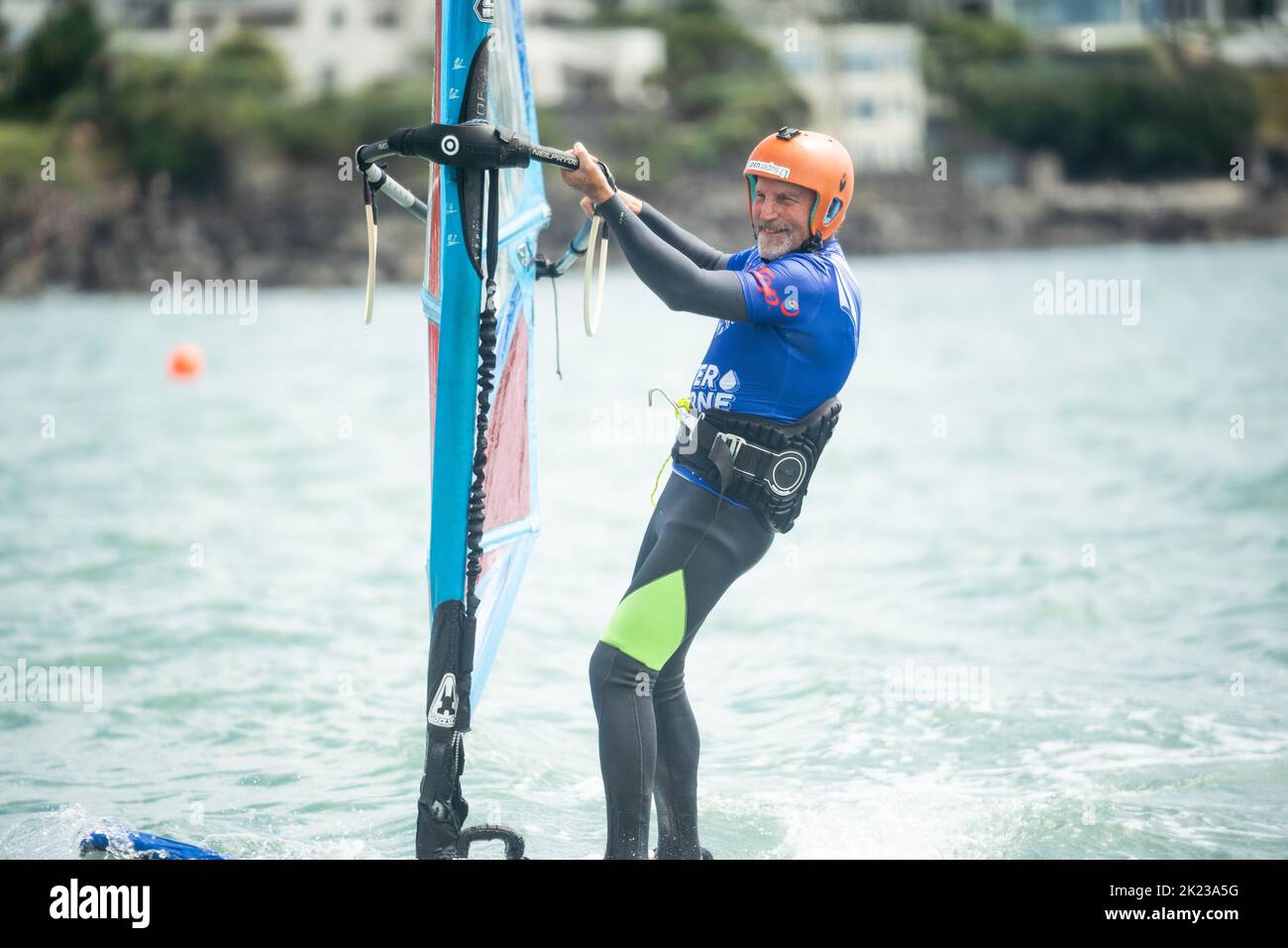 A retired senior man competes in a New Zealand national windsurfing ...