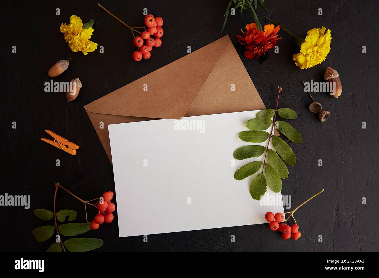 Paper envelope with stationery card mock up among autumn flowers and ...