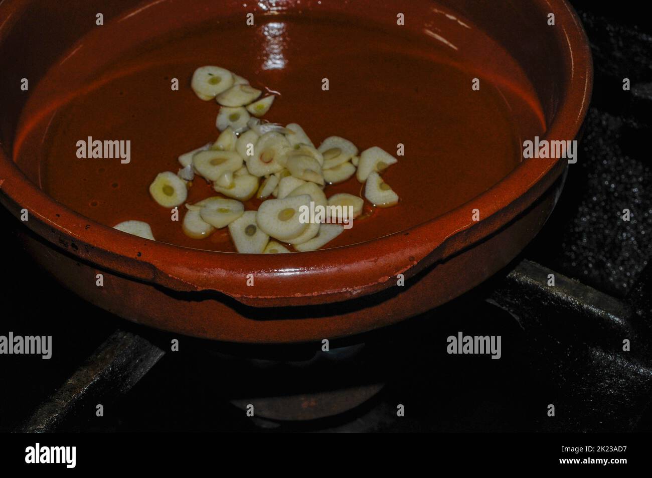 Garlic cut into slices, put in a clay pot Stock Photo - Alamy
