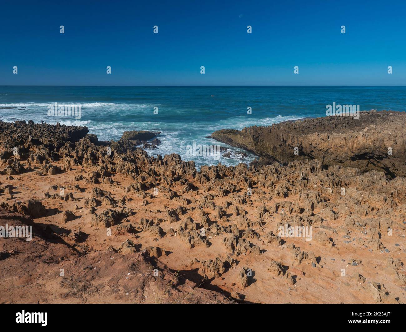 View of wild Rota Vicentina coast with ocean waves and red and orange ...