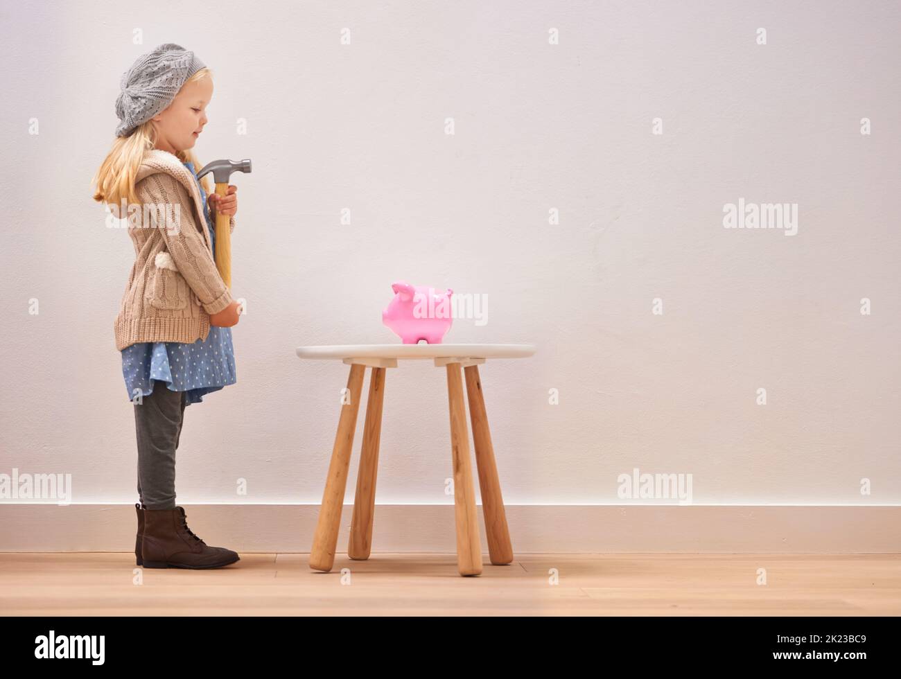 To break or not to break. A little girl standing in front of her piggy ...
