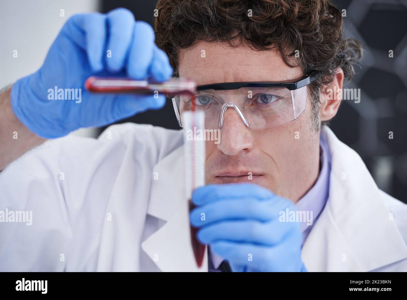 Investigating the secrets of life. A scientist looking at a sample in a ...