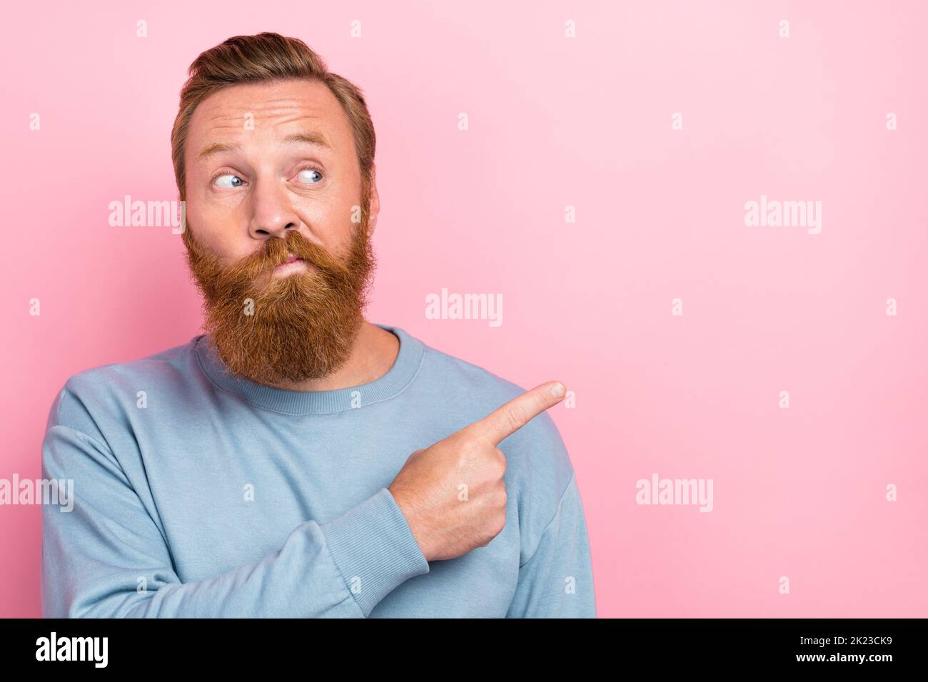 Portrait of positive interested impressed guy with red beard wear blue ...