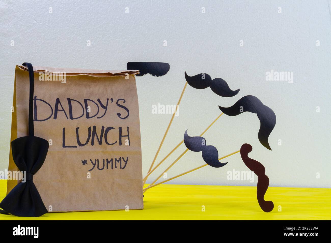 Paper bag with black bow tie for daddys lunch. Isolated on white ...