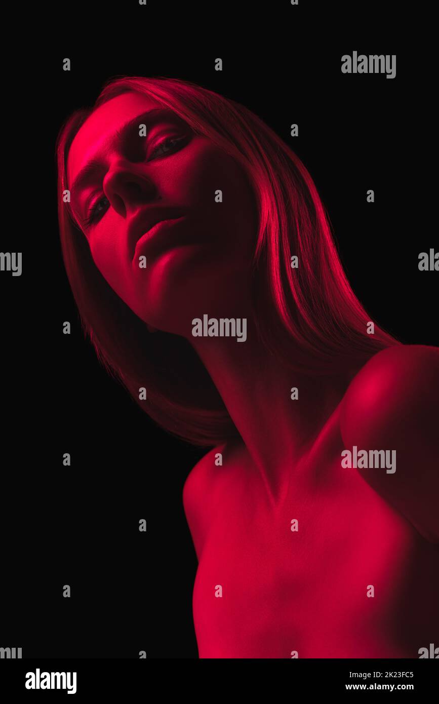 Desire and love. Dark red night. Young sensual woman in neon light on ...