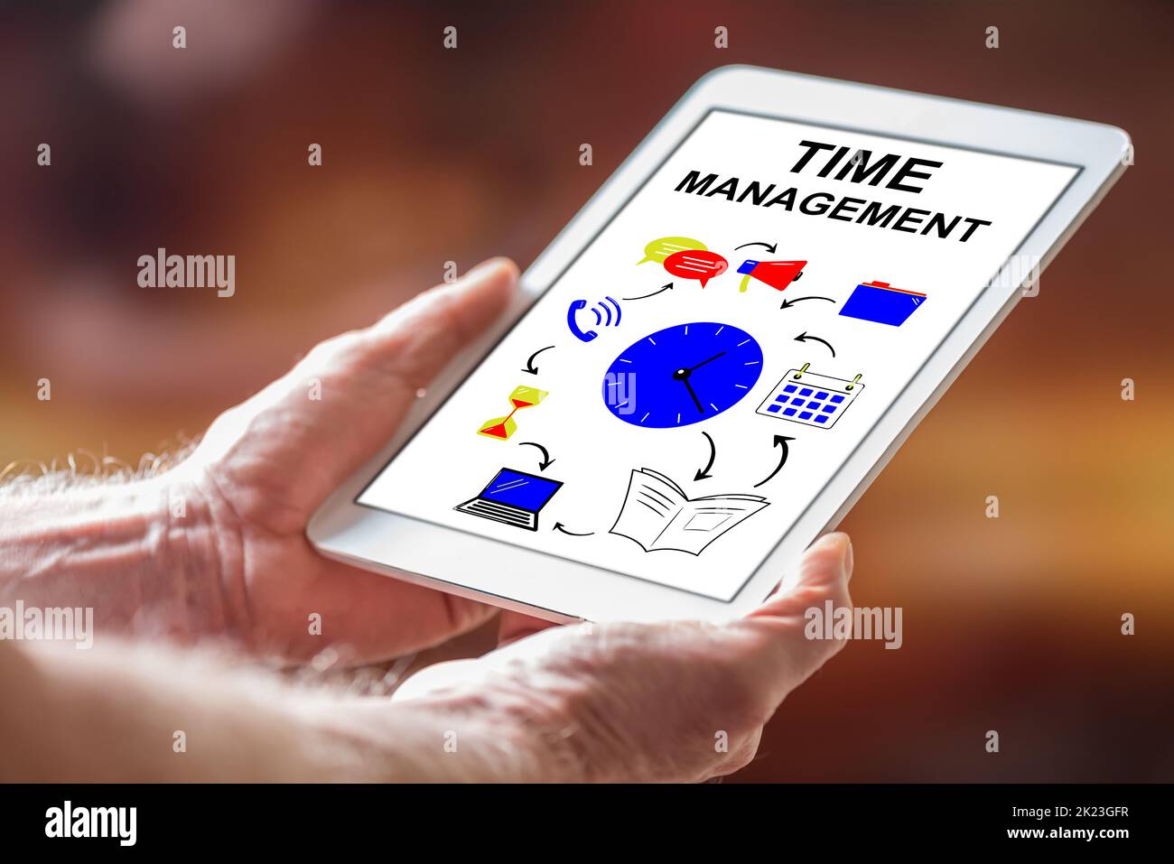 Man holding a tablet showing time management concept Stock Photo - Alamy