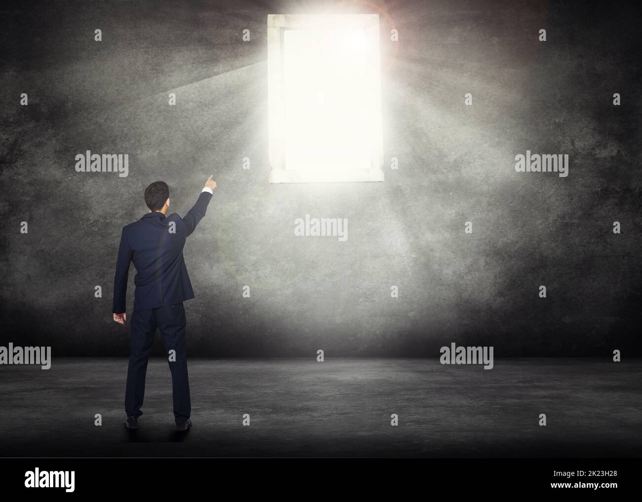 Theres the answer. A rear view of a businessman pointing at a window of ...