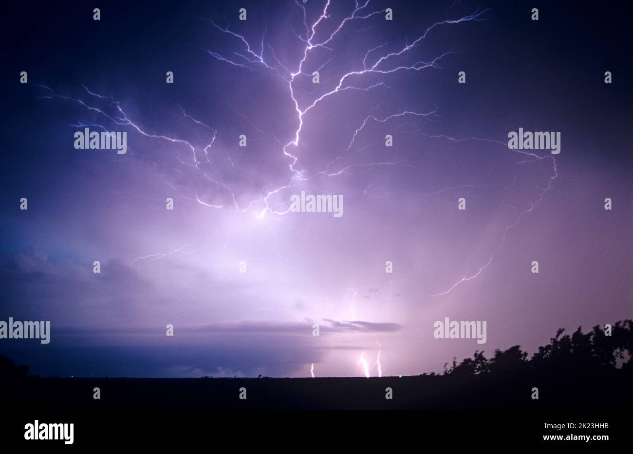 A massive bolt of cloud to cloud lightning crawls across the anvil of a ...