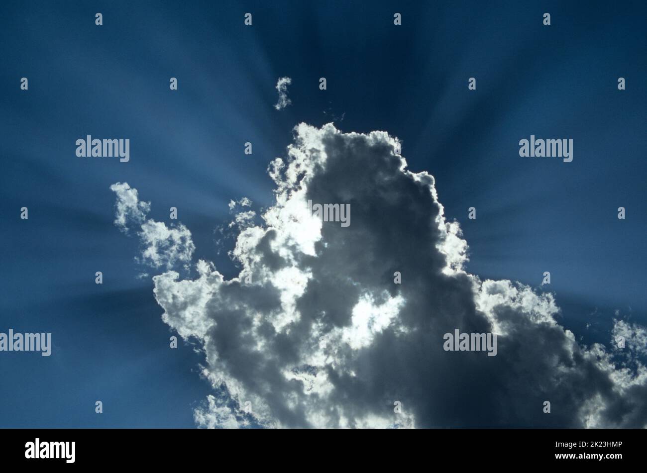 Crepuscular rays burst from behind a cloud Stock Photo - Alamy