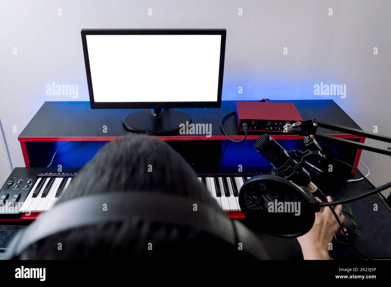rear overhead view of man with headphones, looking at the computer ...