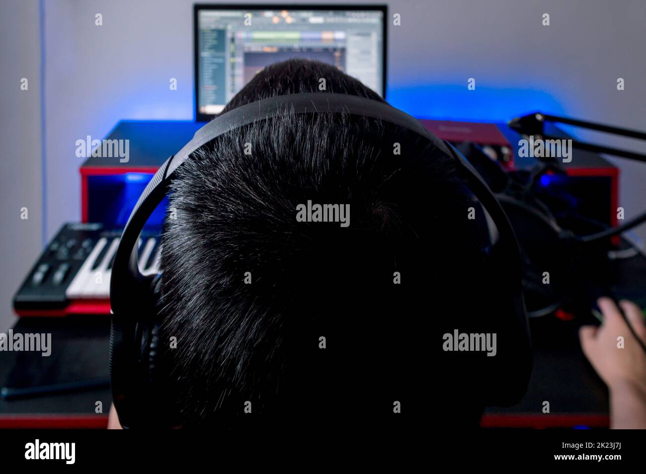 Wide angle rear overhead view of man with headphones and short black ...