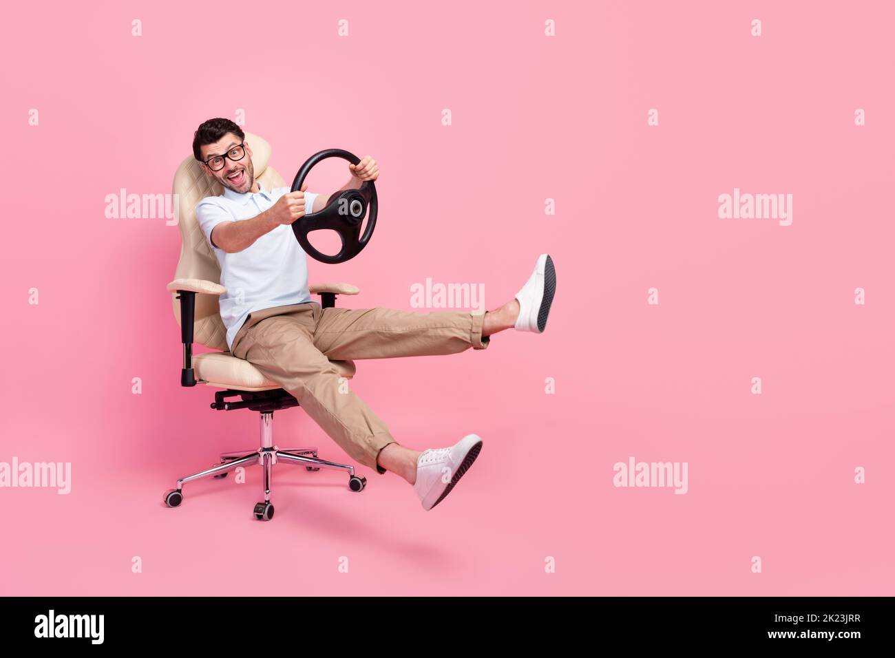 Full length photo of carefree worker guy sit chair hold steering wheel ...