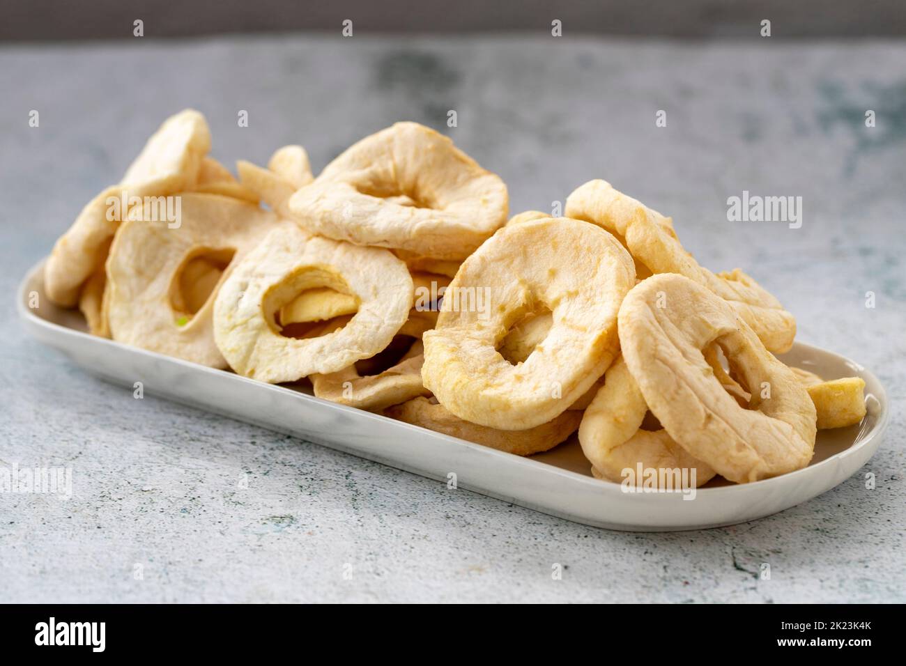 Dried apple slice on gray background. Dried fruit in sunlight. close up ...
