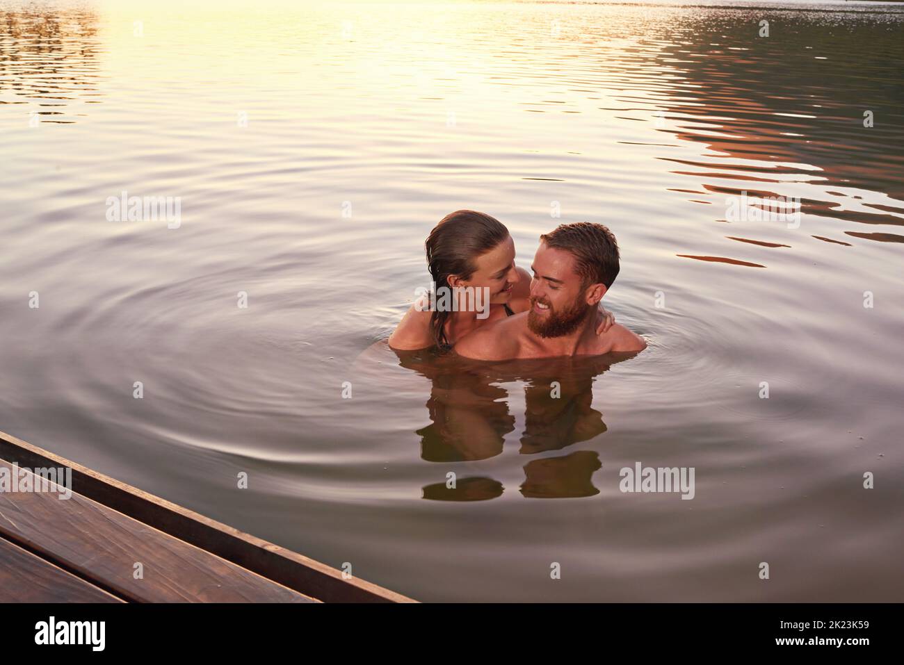 Enjoying a romantic swim. an affectionate young couple enjoying a swim together at a lake Stock ...