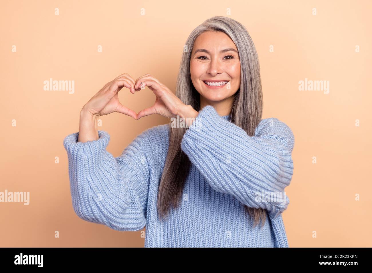 Photo of pretty shiny retired lady wear blue sweater showing arms heart ...
