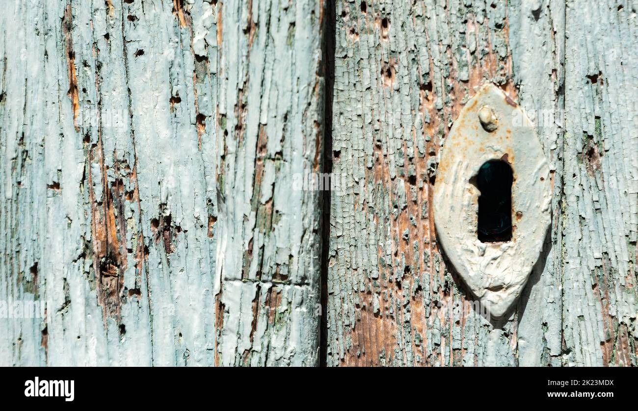 The old plank rotted with paint peeling off the keyhole. Wooden ...