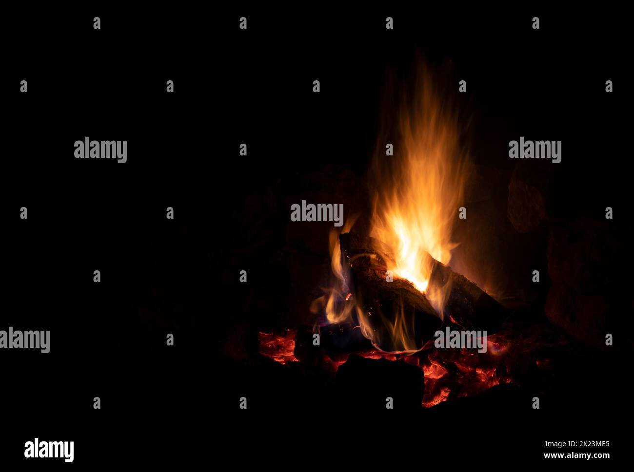 Campfire burning in the dark with a ring of rocks Stock Photo - Alamy